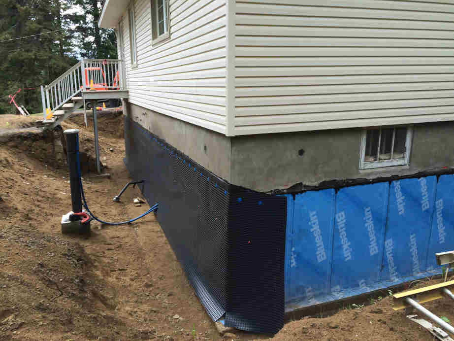 Imperméabilisation fondations: pose de la membrane élastomère et alvéolée